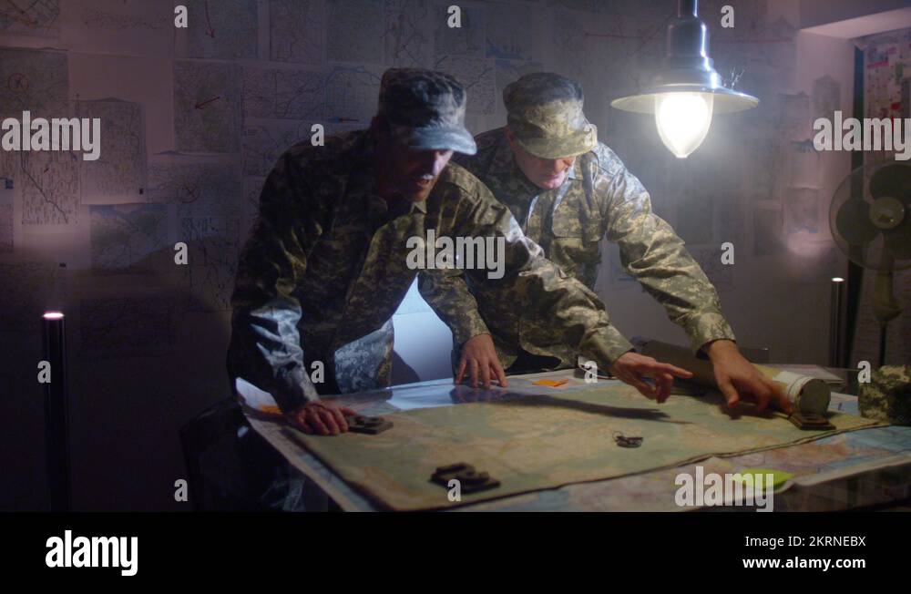 4K Military officers in army bunker, looking at map & discussing battle ...