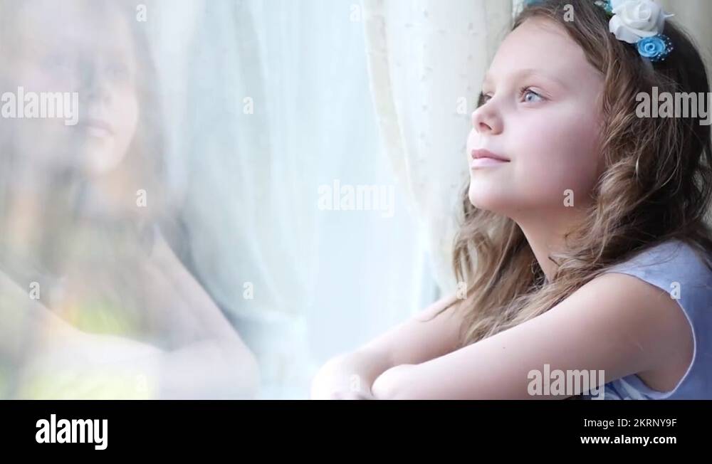 Pretty face little girl dreamily sitting smiling by the window Stock ...