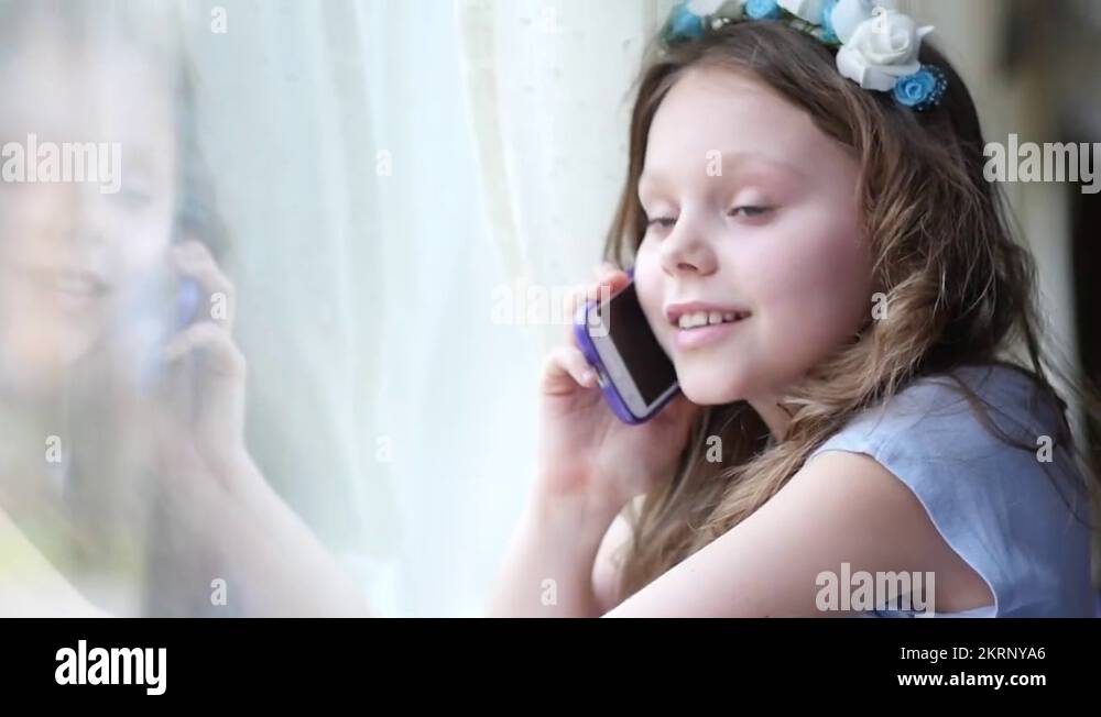 Pretty face little girl speaking on cell phone by the window Stock ...