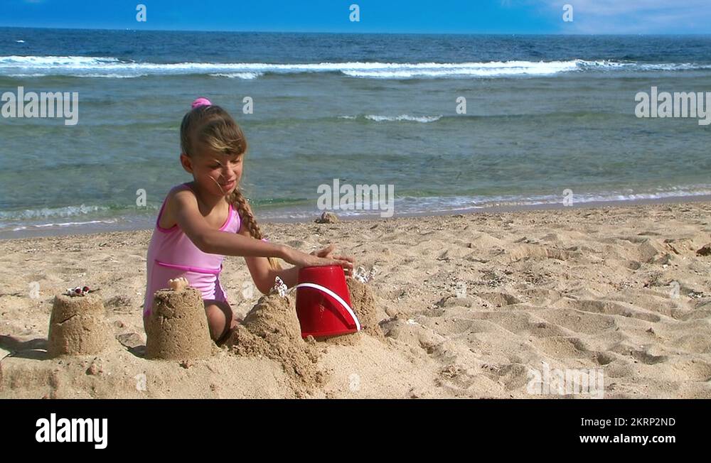 Girls making sandcastles on beach Stock Video Footage - Alamy