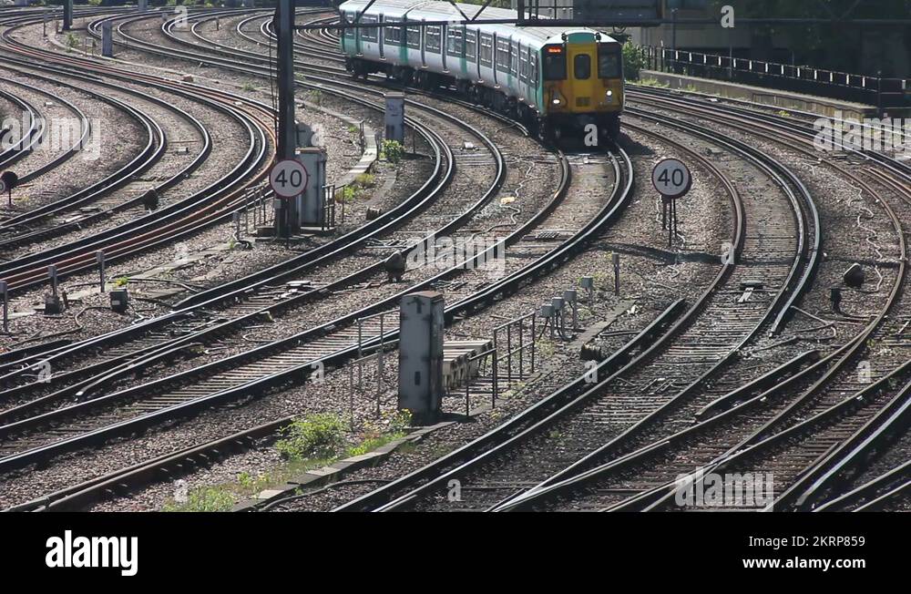 Electric commuter train and an express train round a curve to enter ...