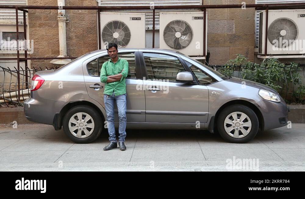 Indian man posing by a modern car in suburban street in Mumbai Stock ...