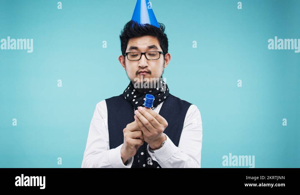 Crazy face Asian man pulling party popper slow motion photo booth blue ...
