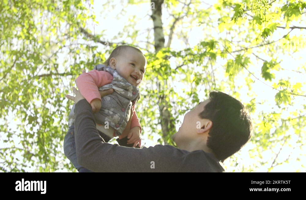Young asian father lovingly holding up cute baby while they play ...