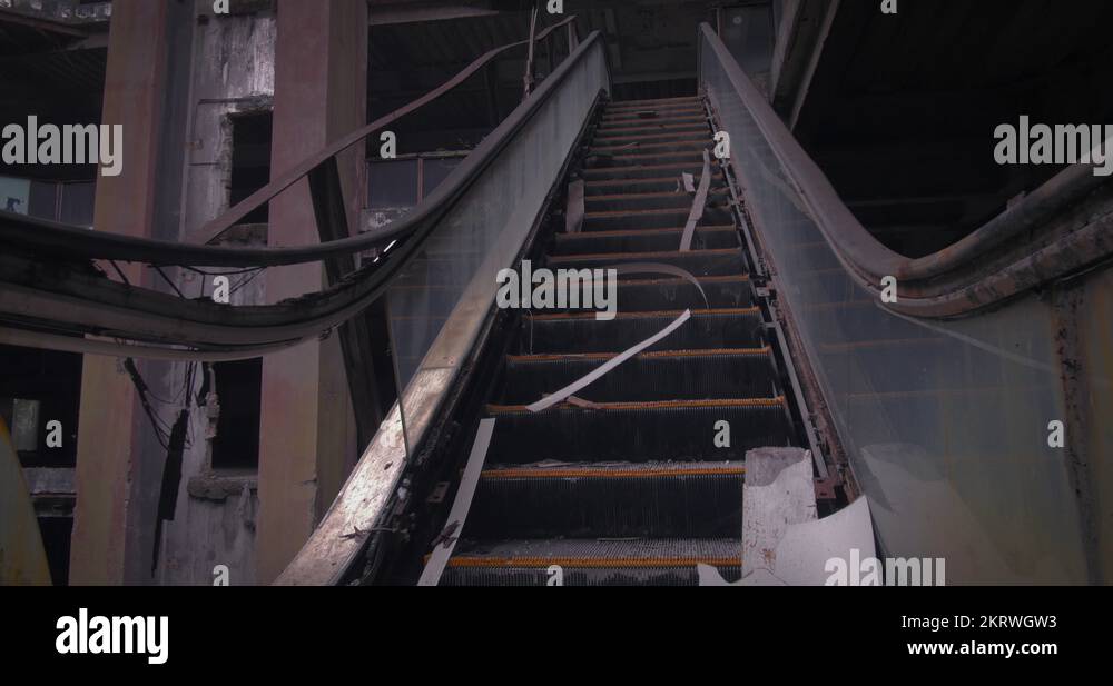 Broken facilities of former shopping mall. Destroyed escalator in empty ...
