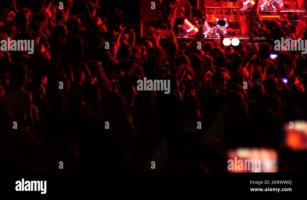 Cheering spectators audience jumping clapping hands up in air on rock ...