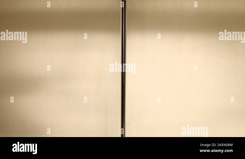 The gold metal elevator doors opening and closing on the white ...