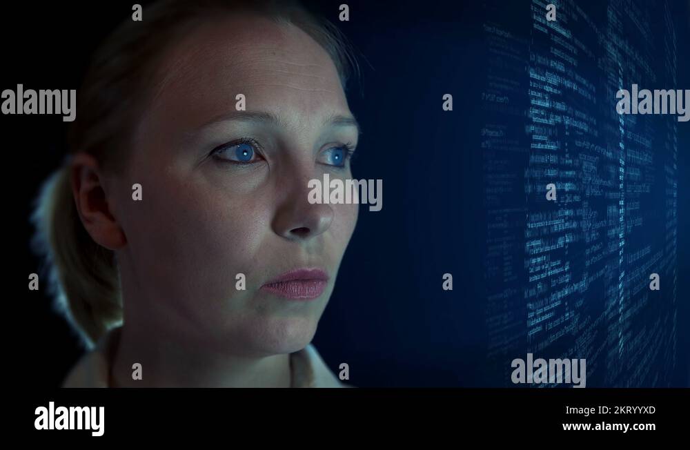 Female employee looking at layers of code off to the side dark ...