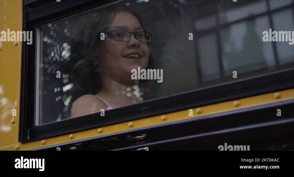 Nerdy girl smiling in window of bus Stock Video Footage - Alamy