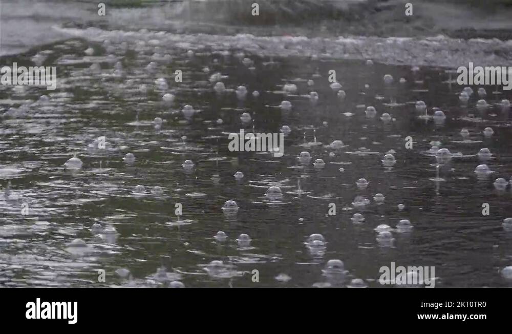 Rain drops falling in the puddle, slow motion, bubbles on surface of ...