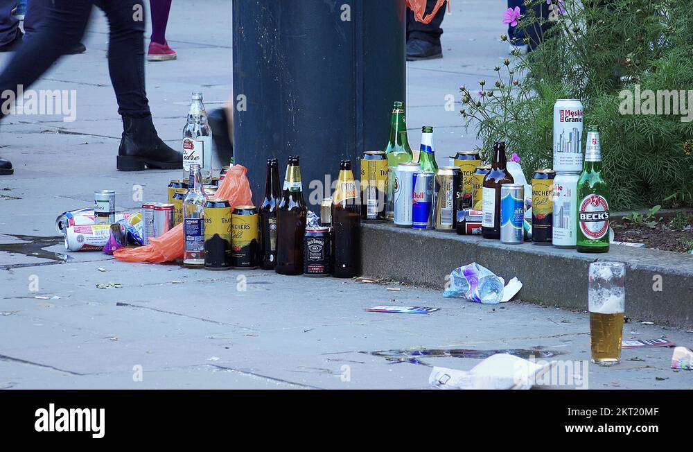 Trash spilling out of overfilled trash plastic bag on city street Stock ...
