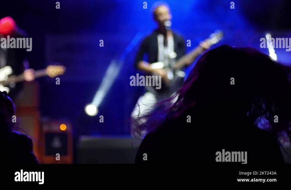 Rock fan silhouette shaking spinning head long hair in concert lumiere ...