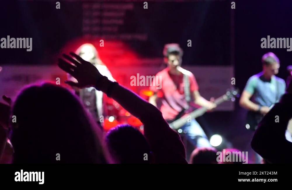 Young fan silhouettes cheering hands up in air on a concert flashing ...