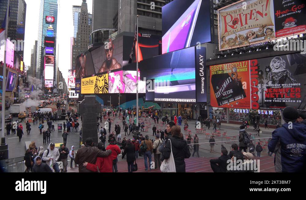 Pan across crowds of people and bright neon advertisements in Times ...