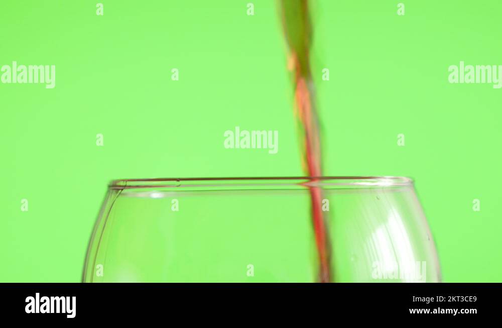 Pouring red rubin color wine in the glass green screen background ...