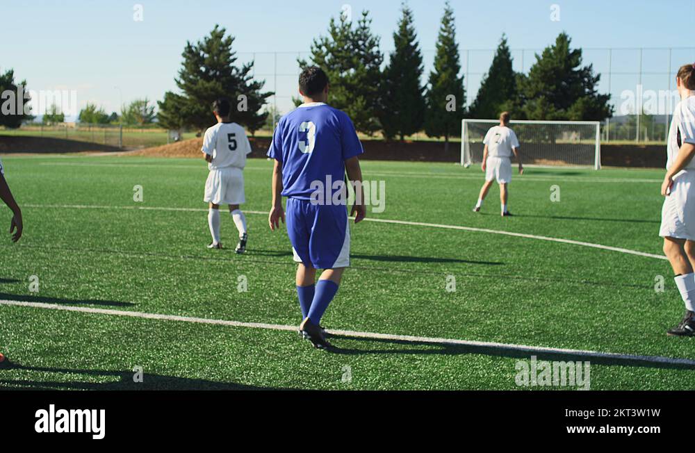 A goalkeeper kicks the ball back into play and the players run down the ...