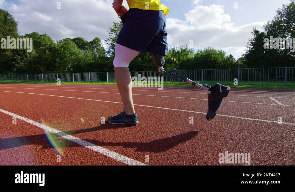 4K Disabled athlete with prosthetic leg running at the running track ...