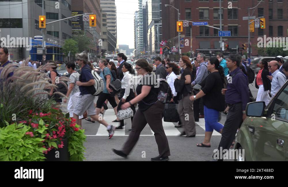 Pan of crowd of Toronto business people and tourists walk across Front ...