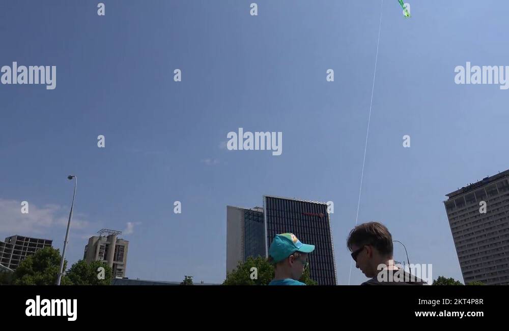 Father teach young boy to fly kite high in sky between skyscraper. 4K ...