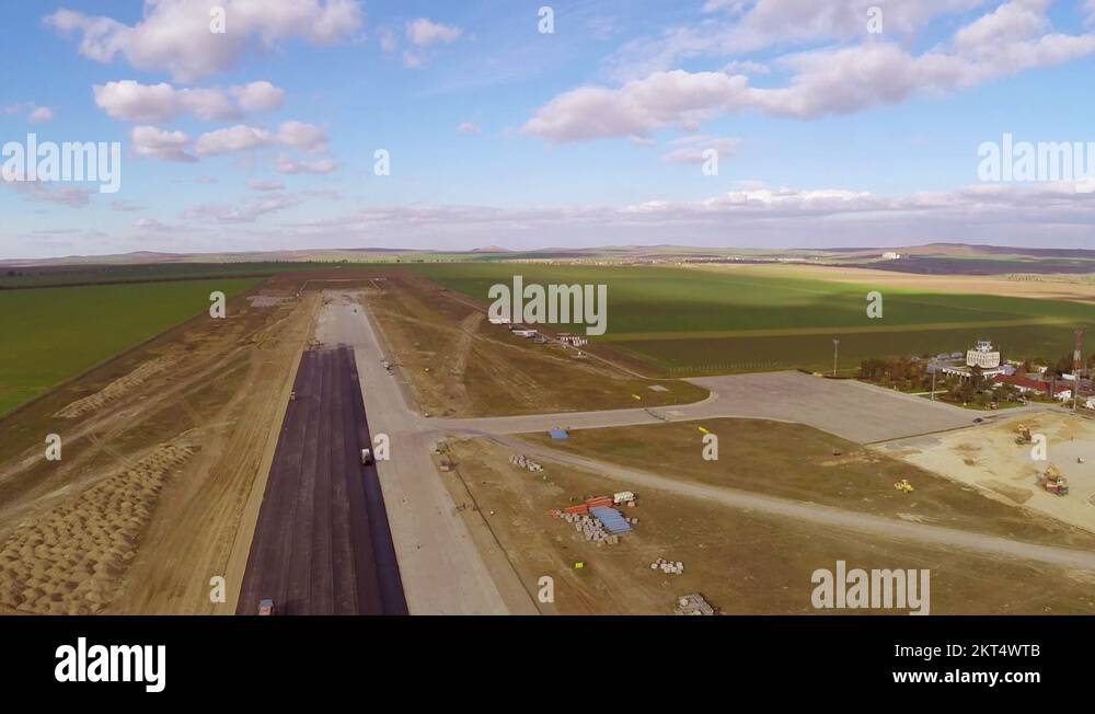 Tracked paver laying fresh asphalt pavement on an airport runway ...