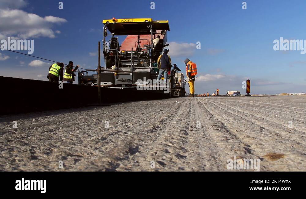 Tracked paver laying fresh asphalt pavement Stock Video Footage - Alamy