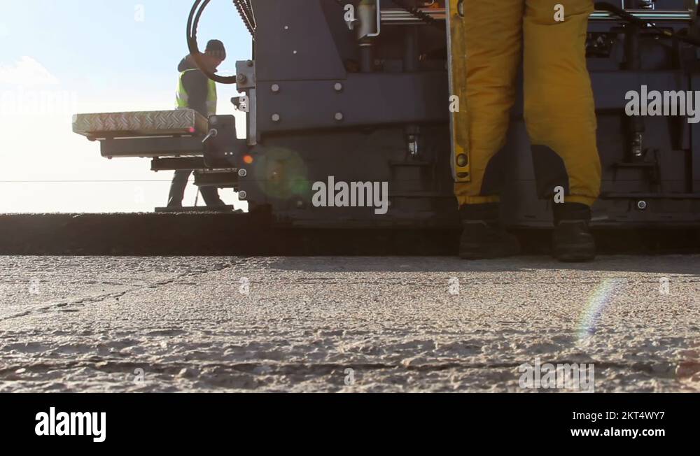 Tracked paver laying fresh asphalt pavement Stock Video Footage - Alamy