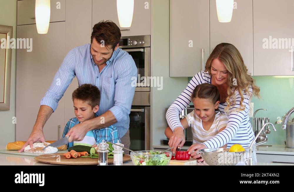Attentive parents and their children cooking together Stock Video ...