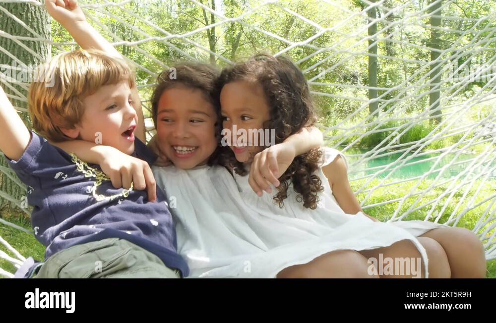 Close up of mixed brothers and sister sitting and laughing together in ...