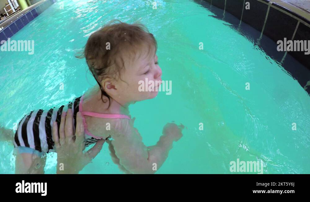 Toddler girl learning how to swim with her mother in indoor swimming ...