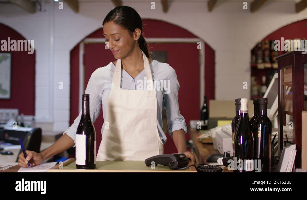 4K Portrait of friendly shopkeeper standing behind counter in wine shop ...