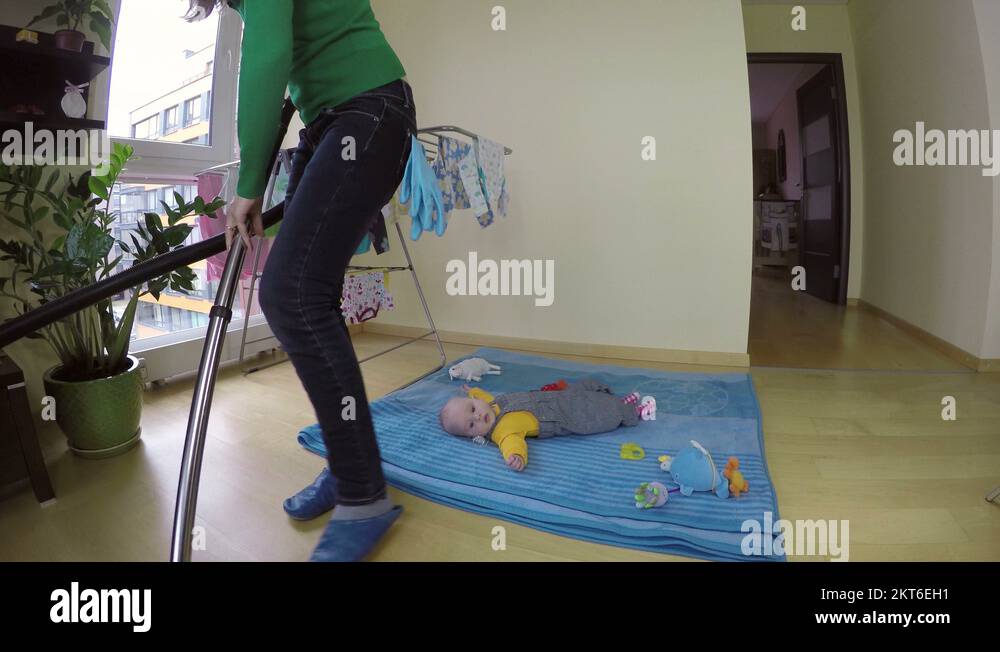 mother look after baby boy and clean home with hoover. 4K Stock Video ...