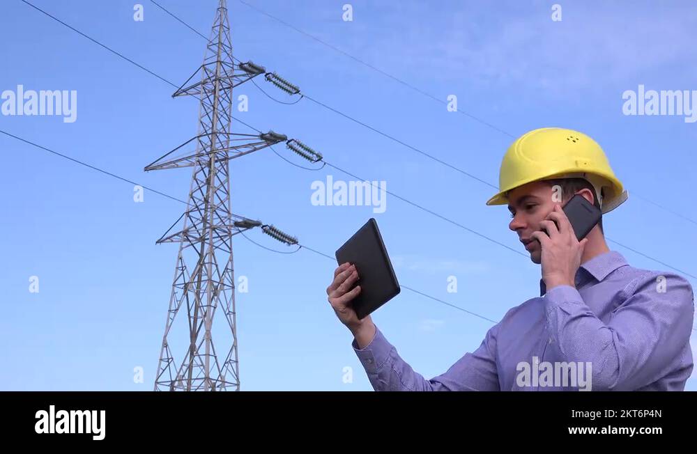 Busy foreman near electrical pillar talking on mobile phone and ...