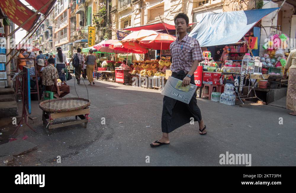 Burmese citizens dressed in traditional clothes walk on market street ...