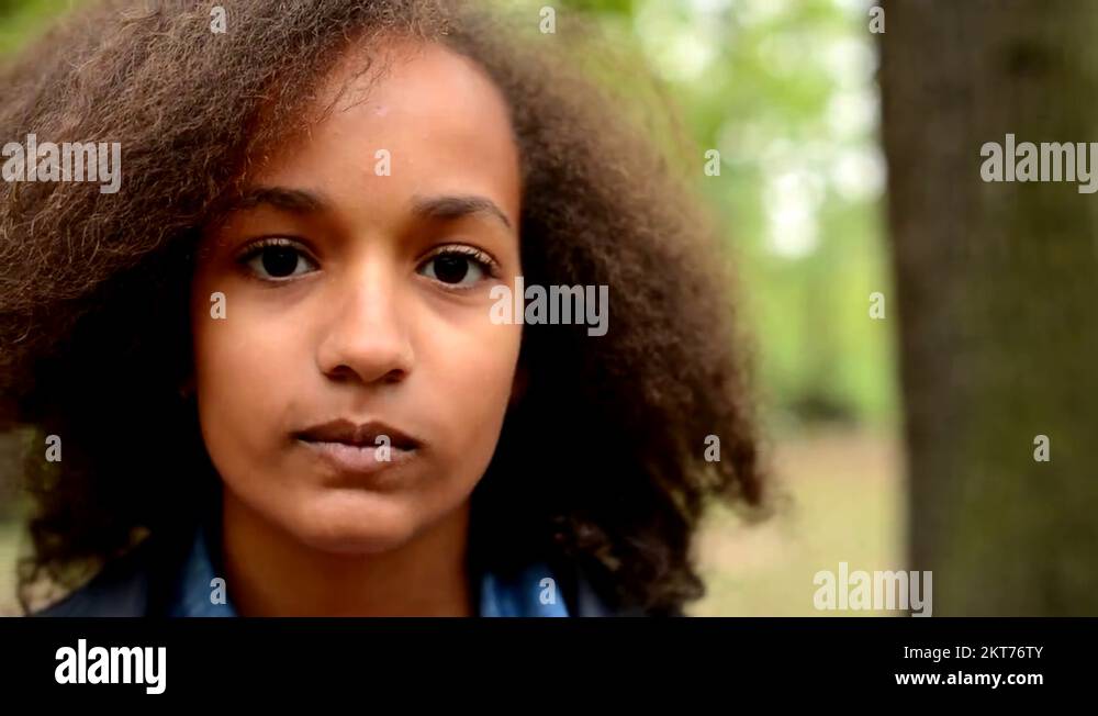young beautiful african girl stare in to camera and blink - face detail ...