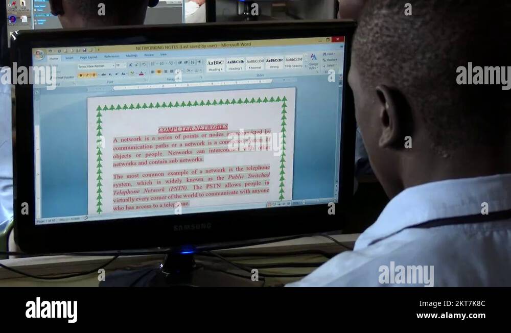 African student reading a computer network article at school using ...