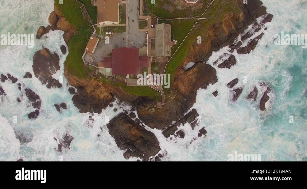 Vertical top down aerial view Ocean waves breaking rocky cliff ...