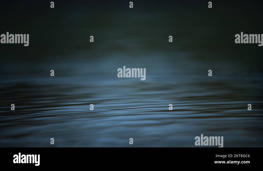 Ultra-slow motion drop flinging bead-like droplets across shadowy green ...