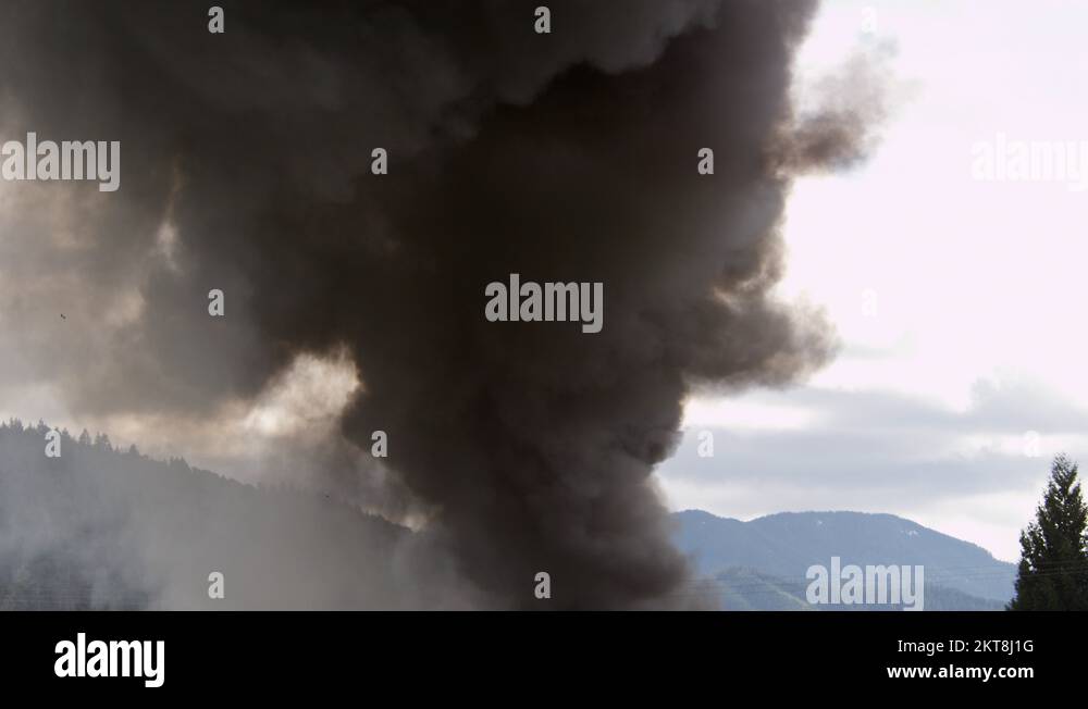 Clouds of thick black smoke rise above a burning structure Stock Video ...