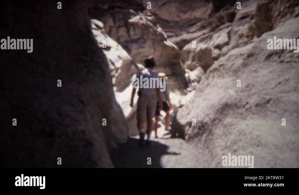 1971: Hikes walking on dry trail rocky smooth cavern cliffs Stock Video ...