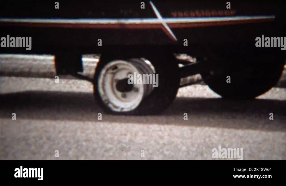 1971: Man fixing flat tire on camping trailer vacationeer vehicle Stock ...