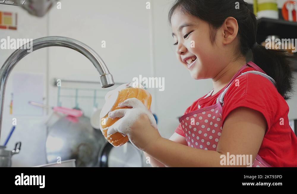 Close up of little Asian girl washing dishes in the kitchen Stock Video ...