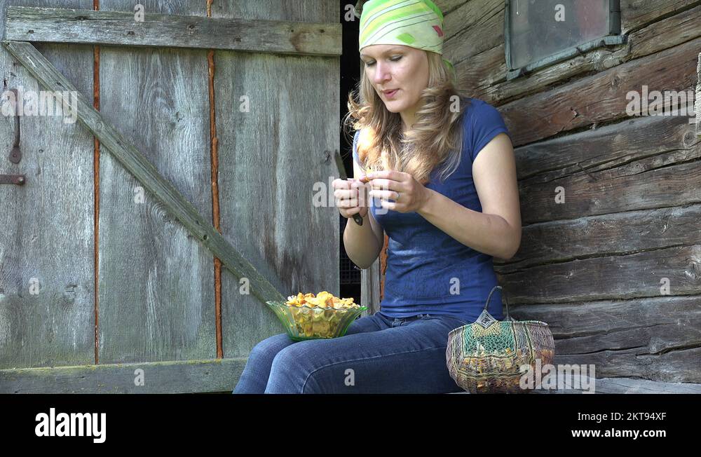 female mushroom picker woman clean dirt from fresh chanterelle fungus ...