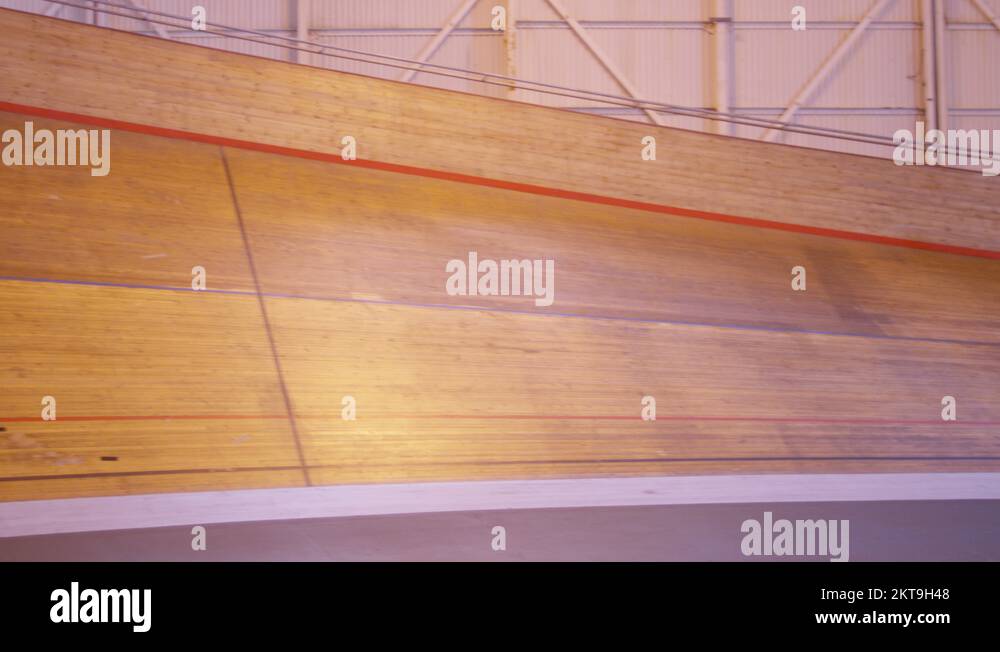 4K Cyclists on racing track in velodrome doing victory lap with flags ...