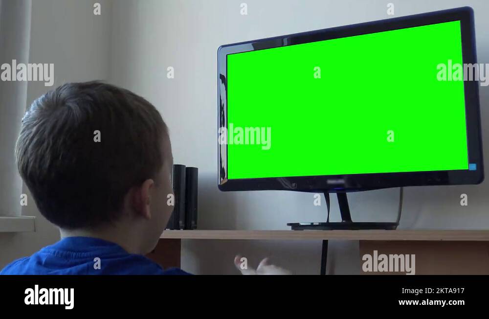young child boy works on computer on the table in room - green screen ...