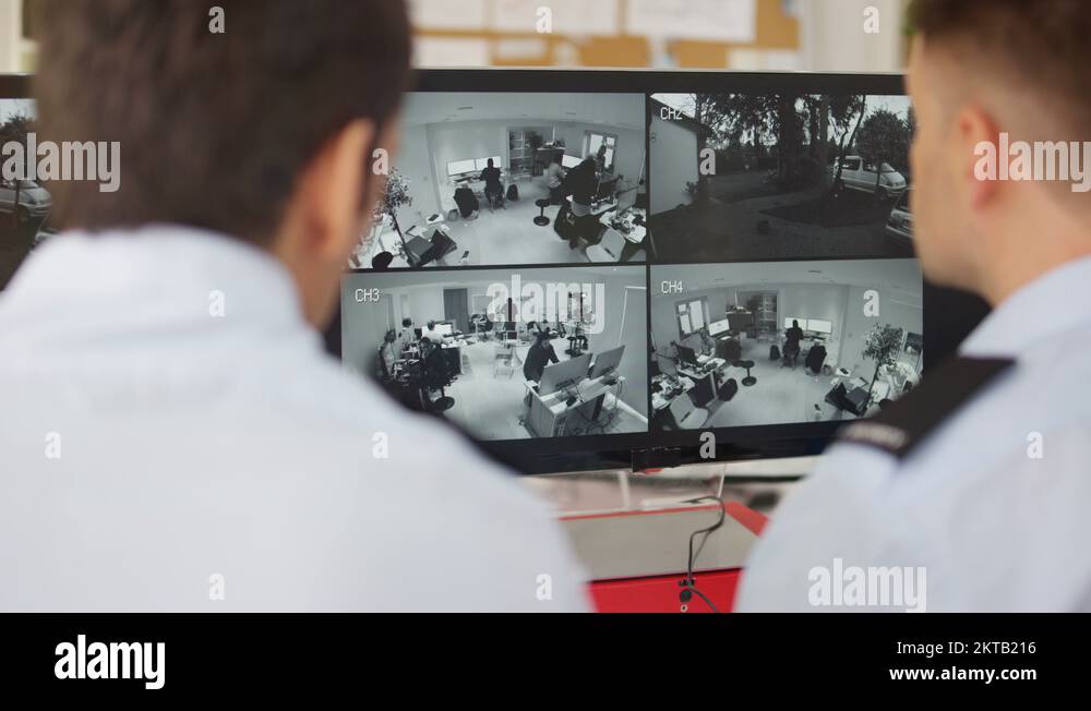 4K Security workers in system control room looking at CCTV on computer ...