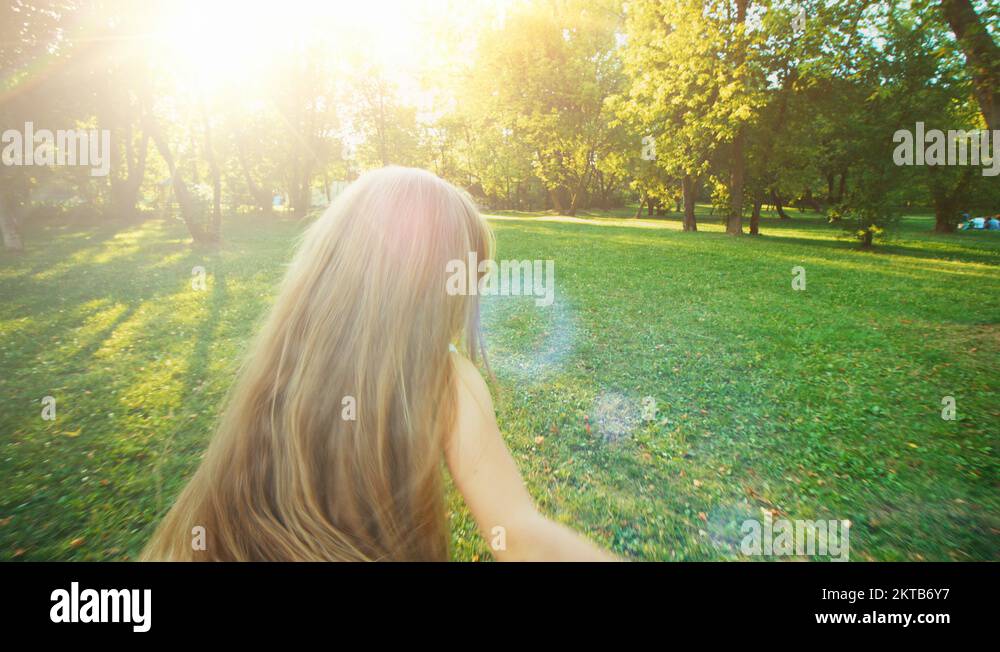 Girl running away from camera in the park. Happy schoolgirl in the ...