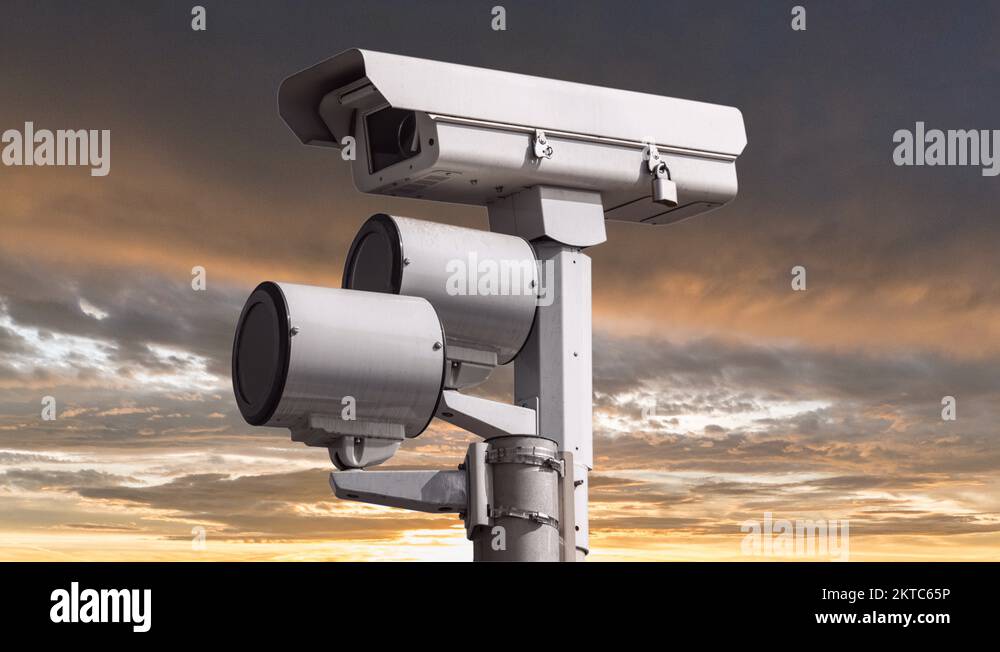 Traffic signal surveillance ticket camera with sunset time lapse sky ...