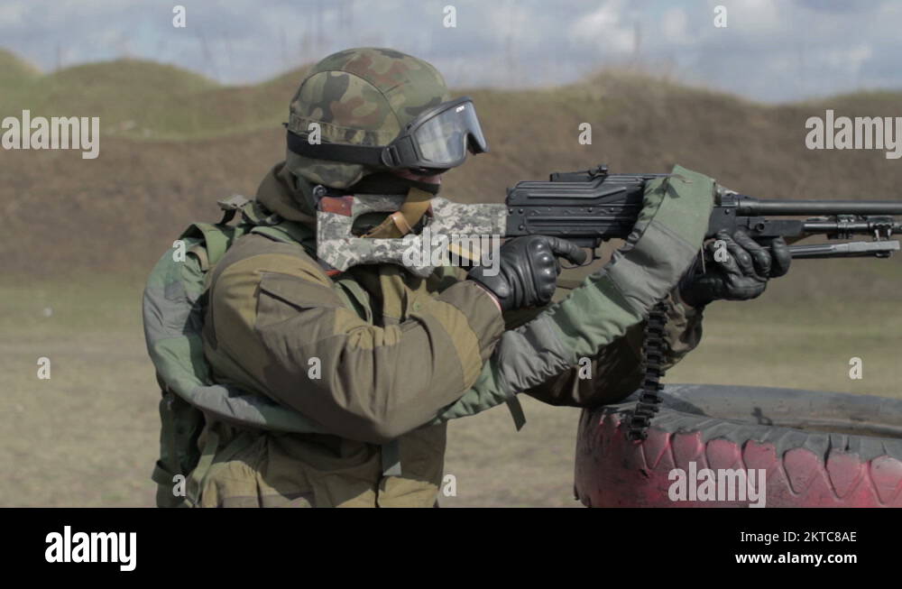 A soldier with a machine gun on a military firing range shooting at a ...