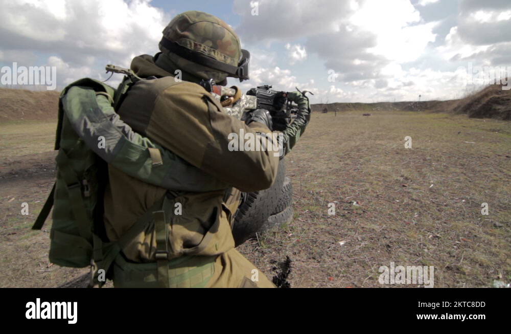 A soldier with a machine gun on a military firing range shooting at a ...