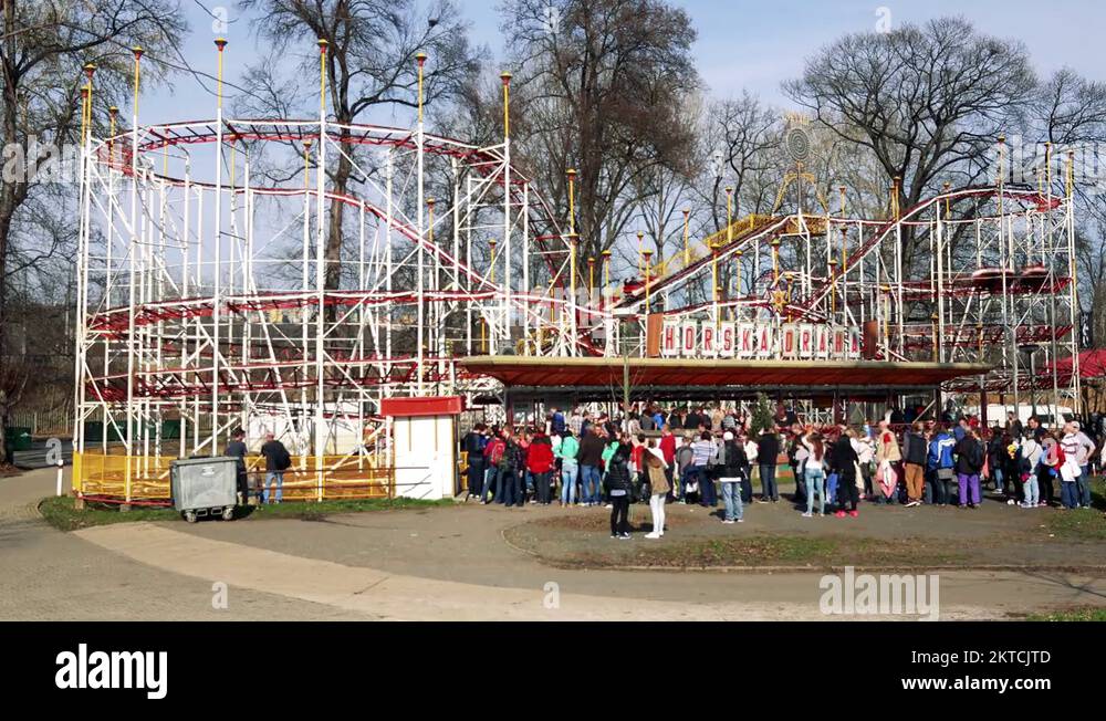 People wait in front of big roller-coaster in funfair Stock Video ...